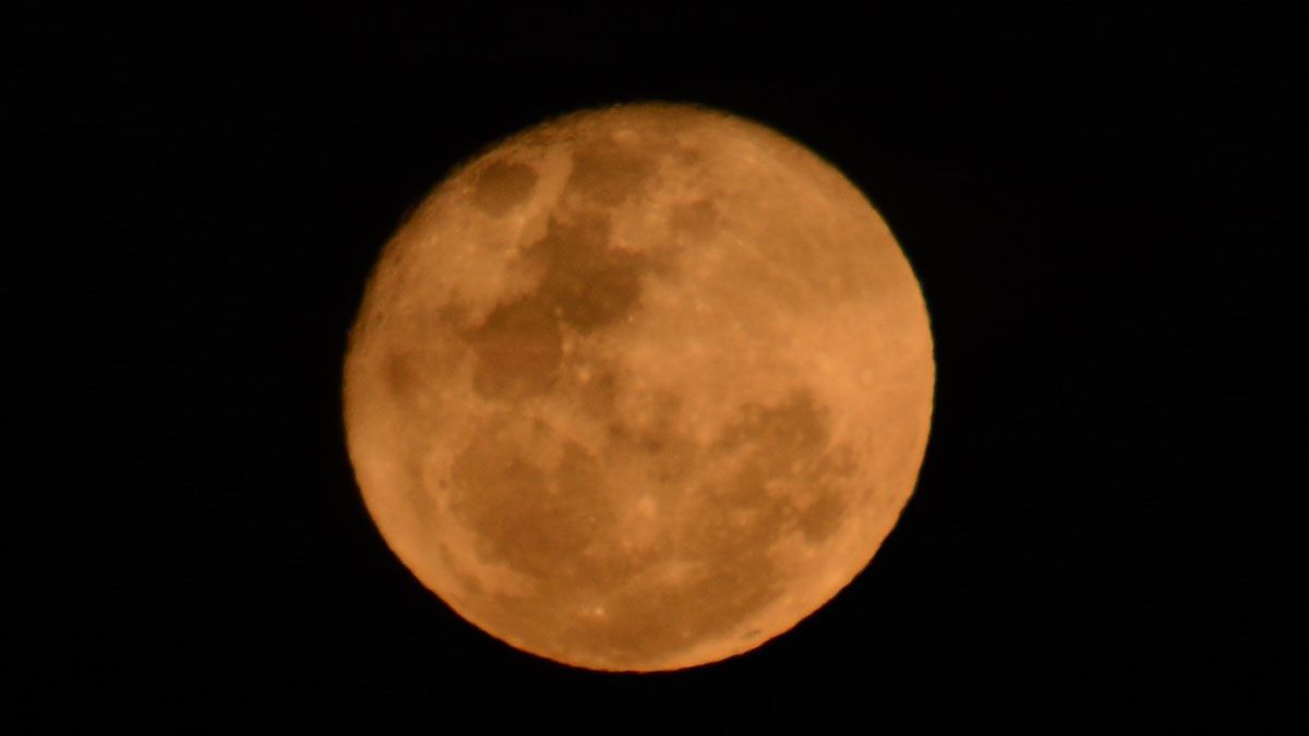 Por las cenizas de los incendios en los pastizales, la Luna se vio rojiza